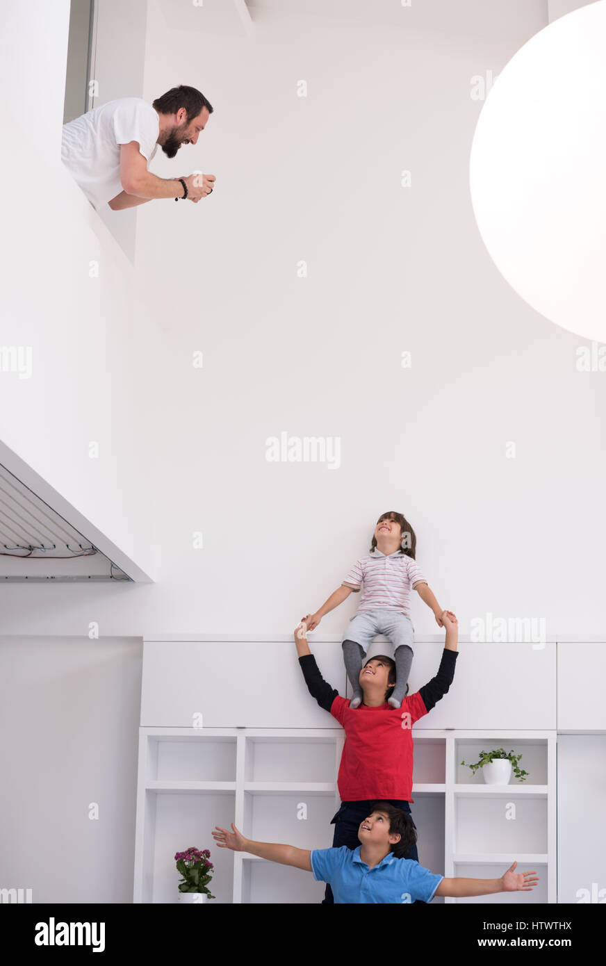 happy young boys having fun and posing line up piggyback in new modern ...