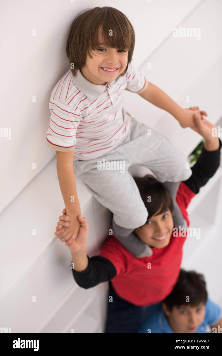 happy young boys having fun and posing line up piggyback in new modern ...