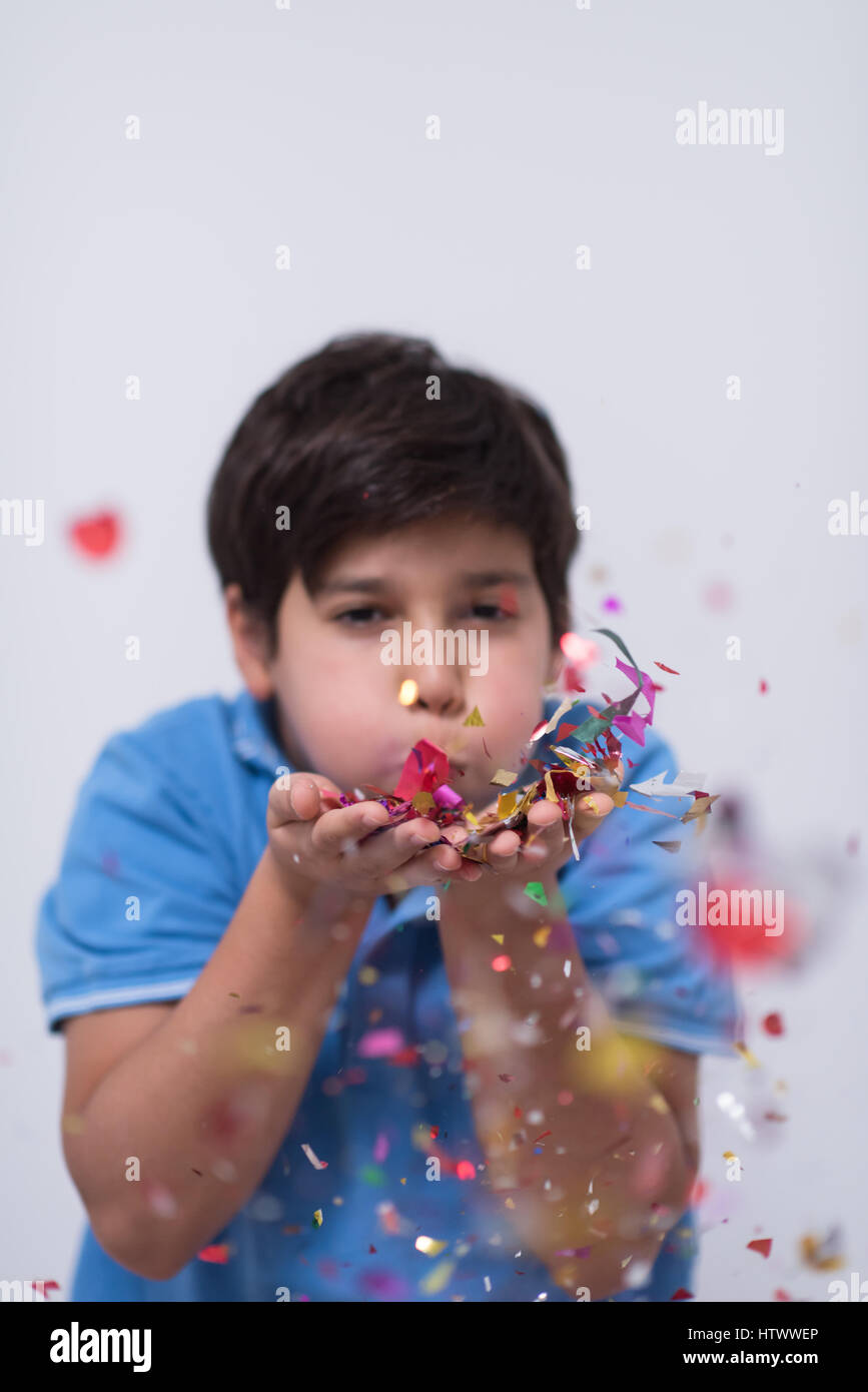 Happy kid celebrating party with blowing confetti Stock Photo - Alamy