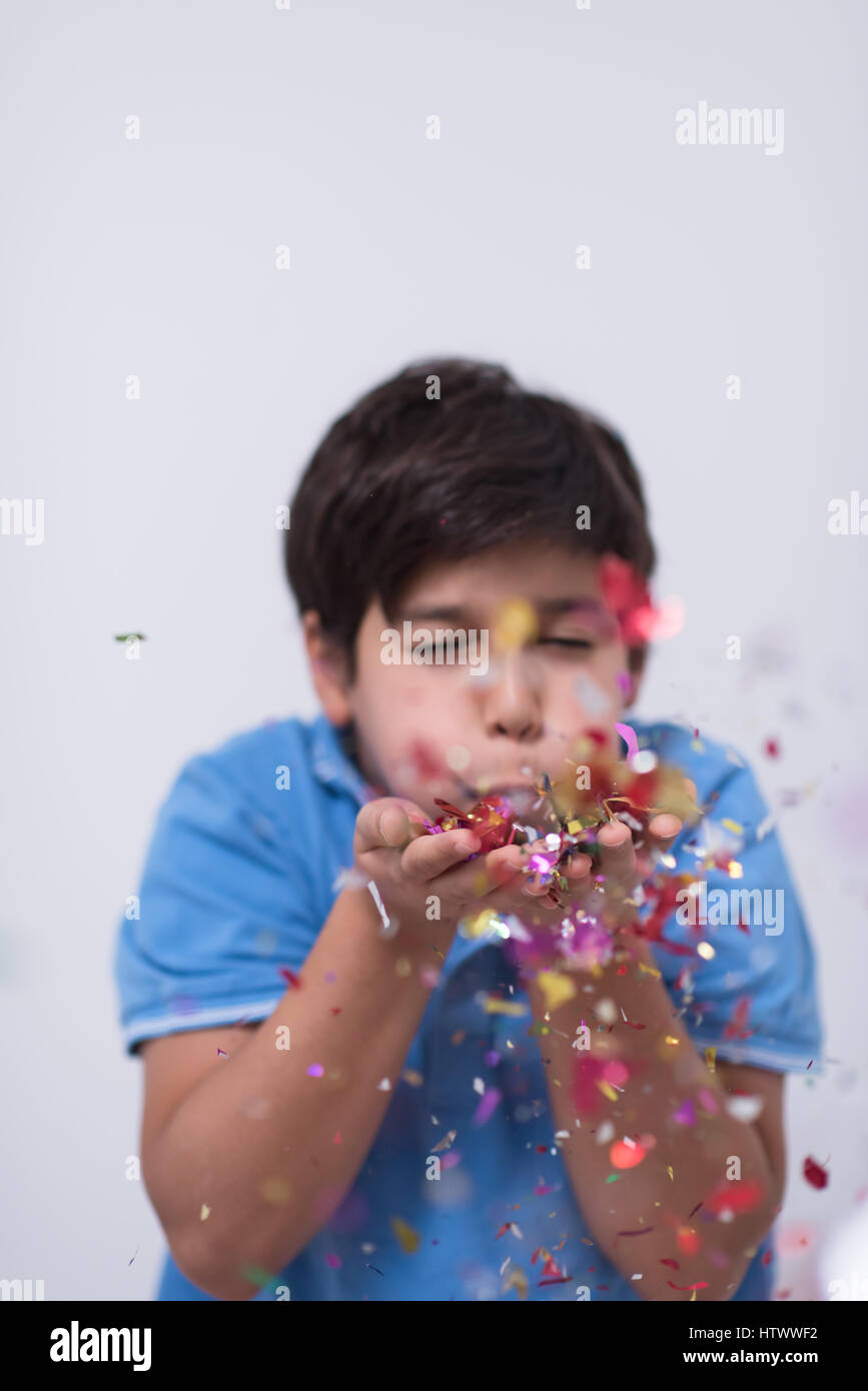Happy kid celebrating party with blowing confetti Stock Photo - Alamy