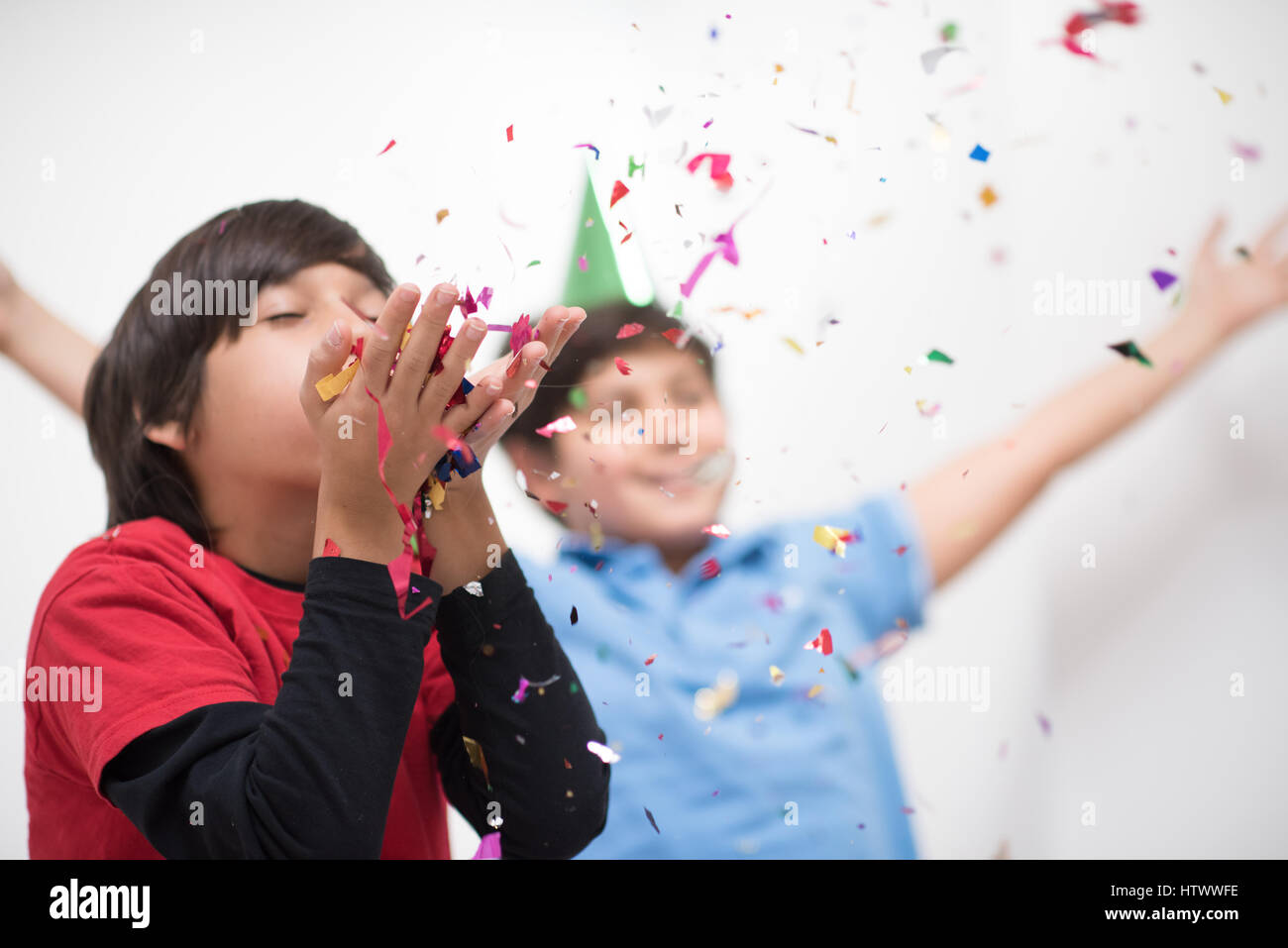 Happy kids celebrating party with blowing confetti Stock Photo - Alamy