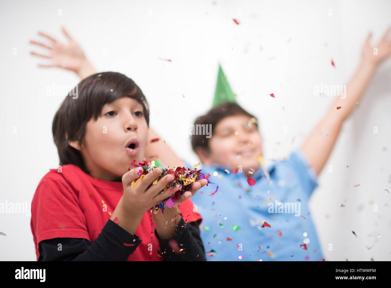 Happy kids celebrating party with blowing confetti Stock Photo - Alamy