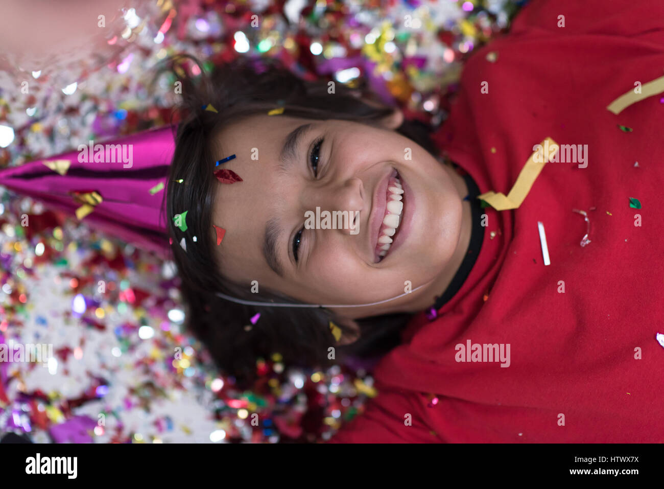 Happy kid celebrating party with blowing confetti while lying on the ...