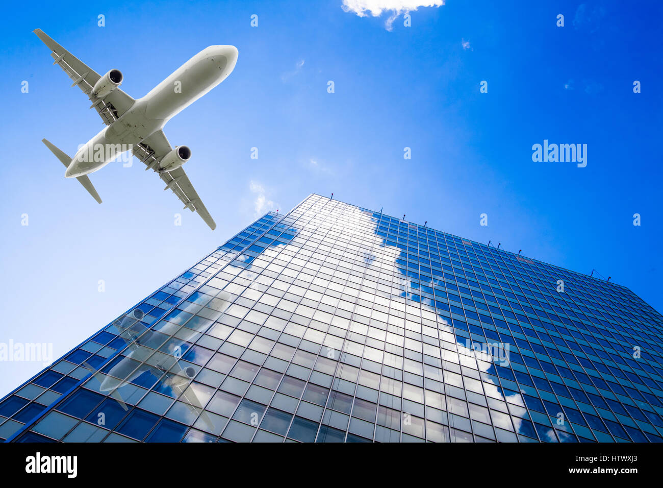 Skyscrapers with a flying airplane against blue sky Stock Photo - Alamy