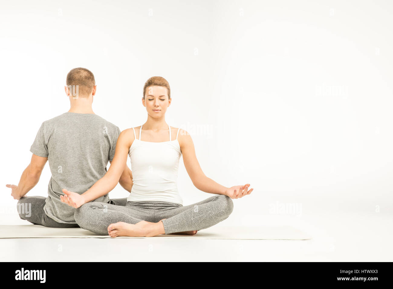 Couple sitting in lotus position Stock Photo - Alamy