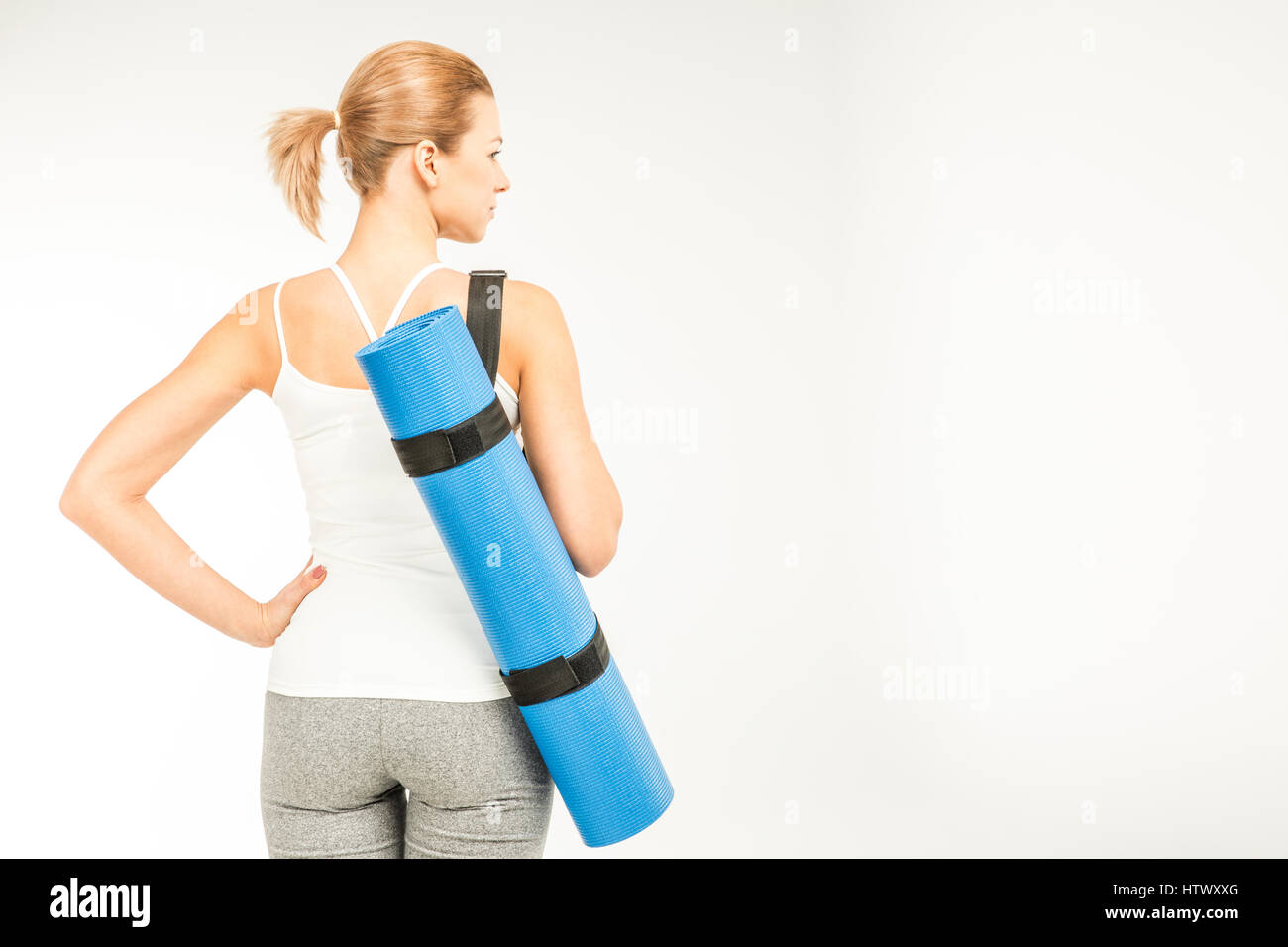 Sportswoman holding yoga mat Stock Photo - Alamy