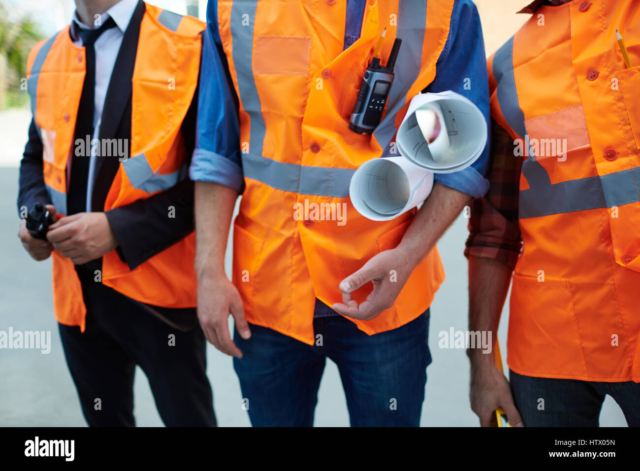 Three builders or architects in uniform standing in row Stock Photo - Alamy