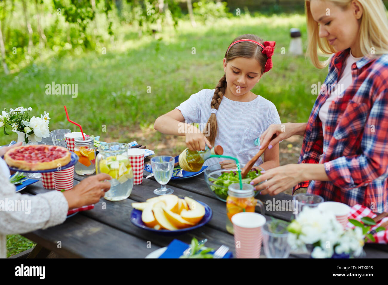 Little girl helping her mother to cook salad for dinner Stock Photo - Alamy