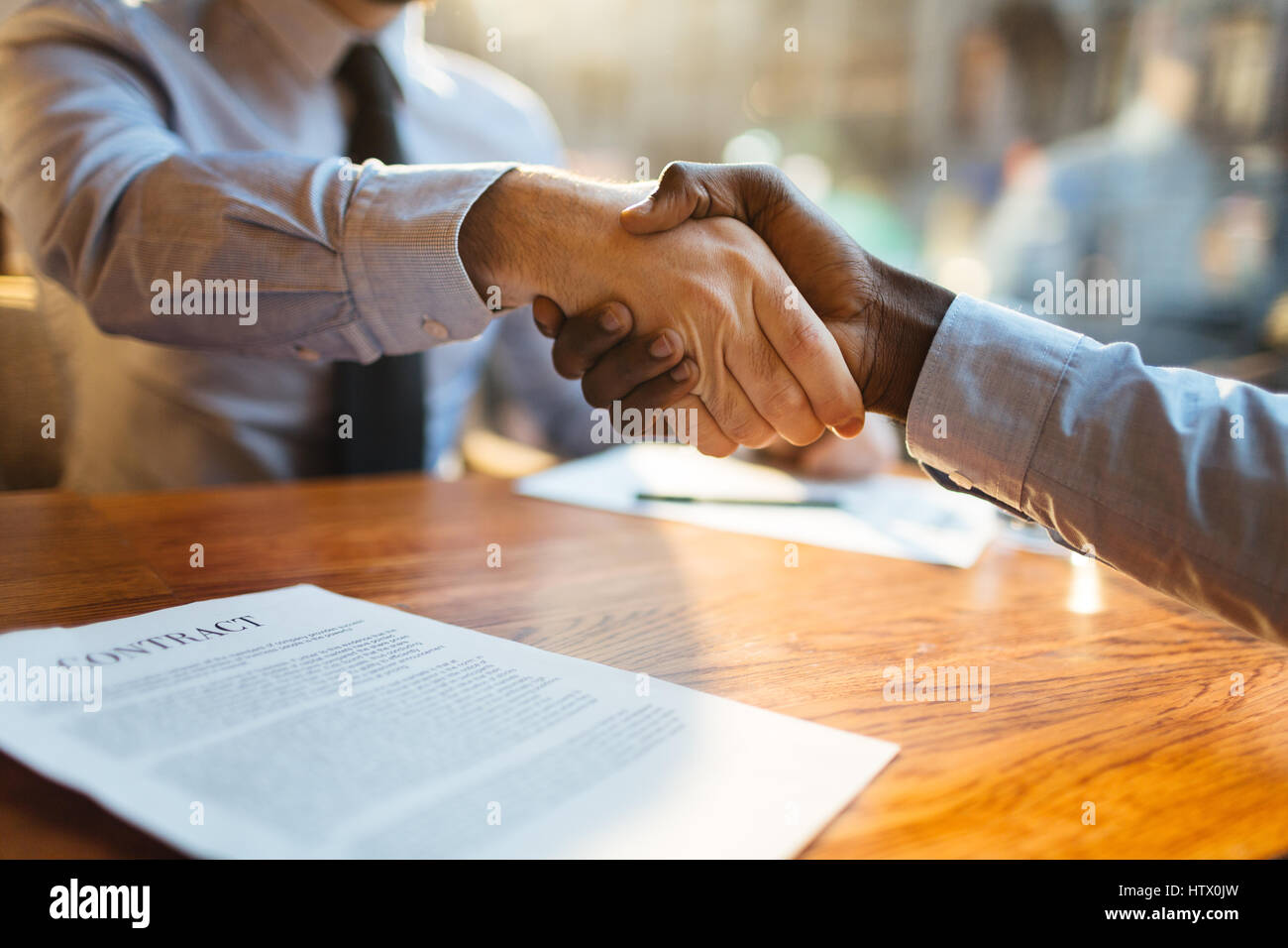 Two human hands in handshake over business contract Stock Photo - Alamy