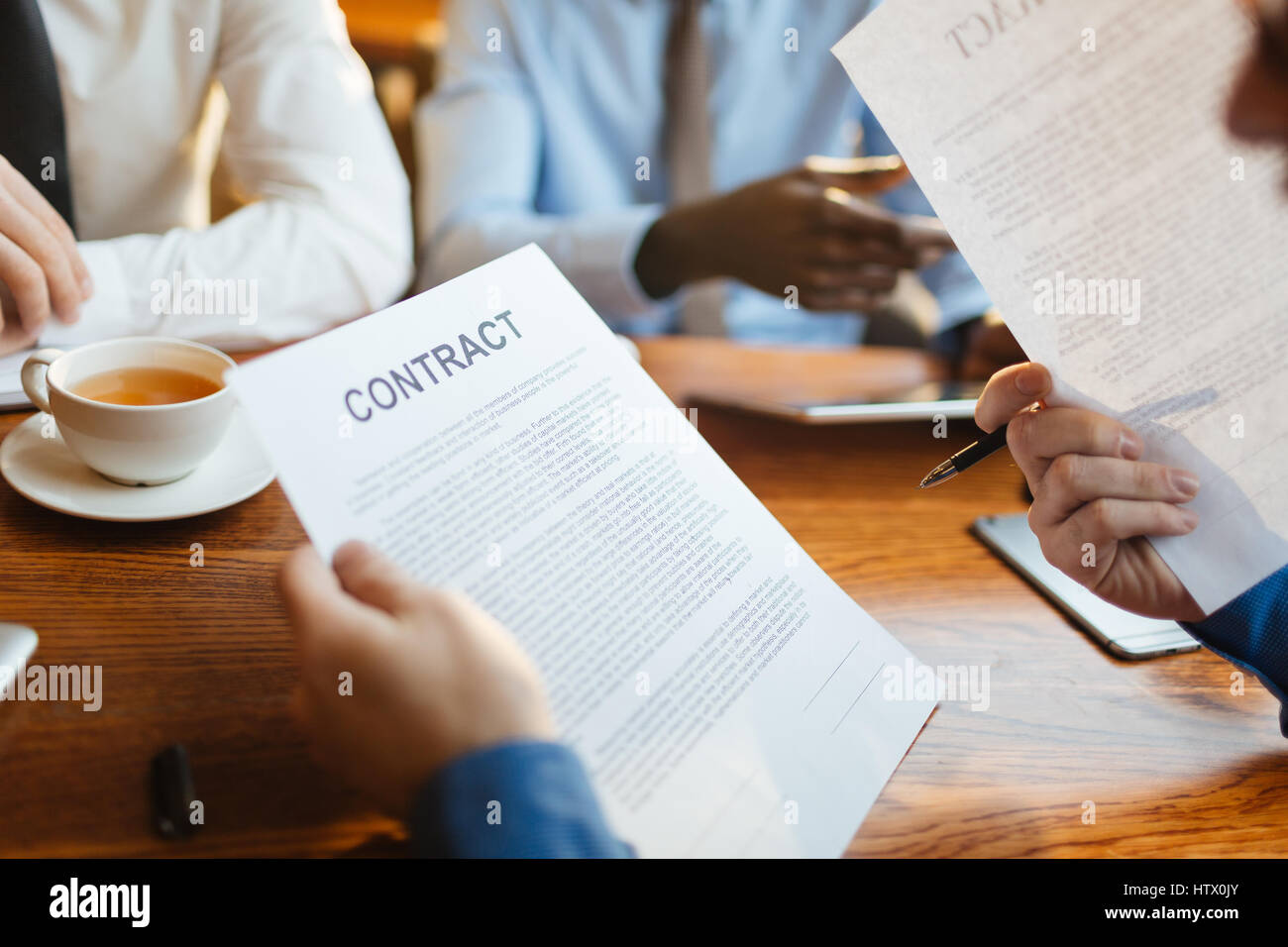 Human looking through business contracts before signing Stock Photo - Alamy