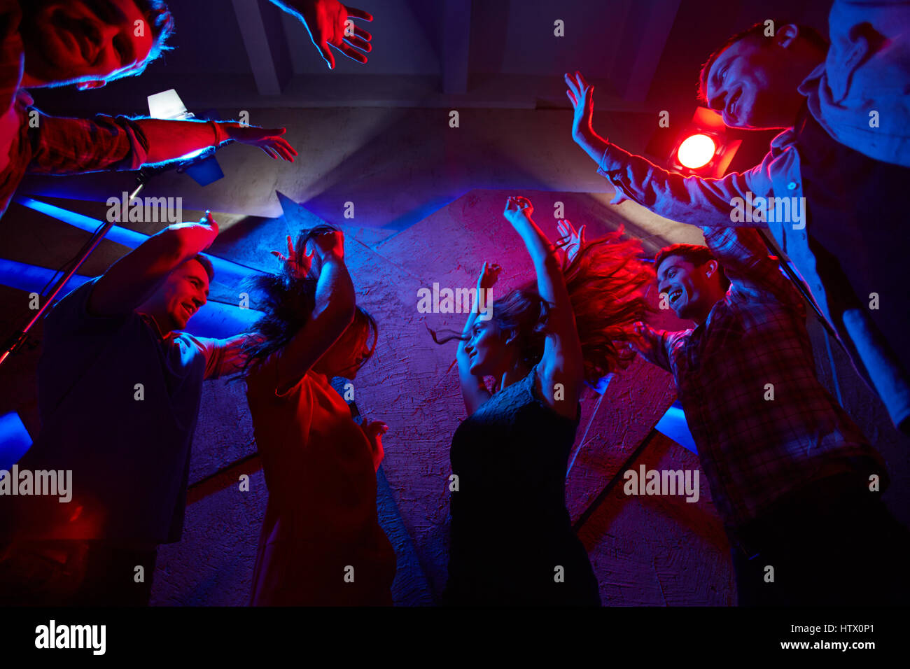 Circle of cheerful friends dancing in night club Stock Photo - Alamy