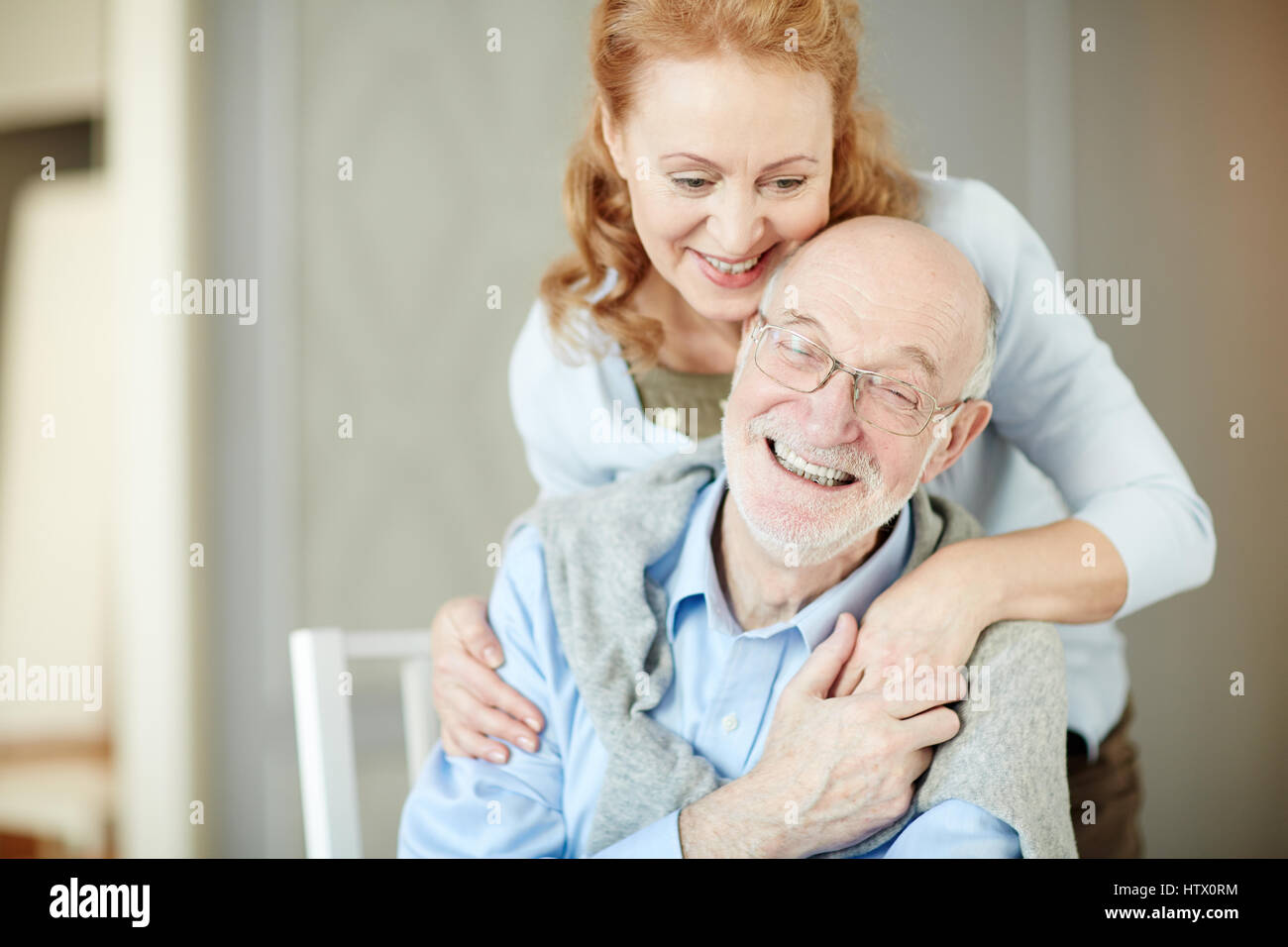Portrait of elderly gray haired man embracing his wife and smiling ...