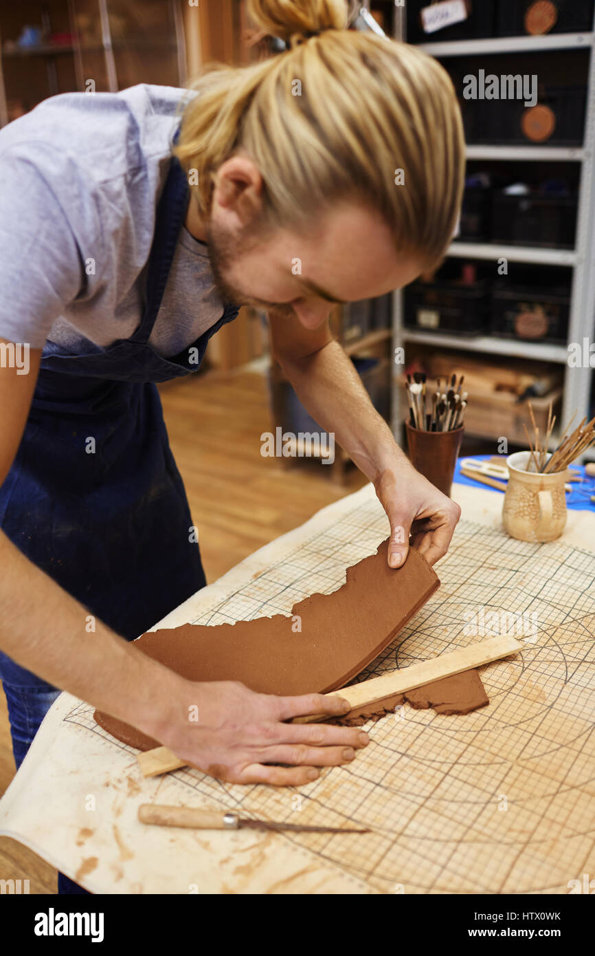 Young potter working with piece of rolled clay Stock Photo - Alamy