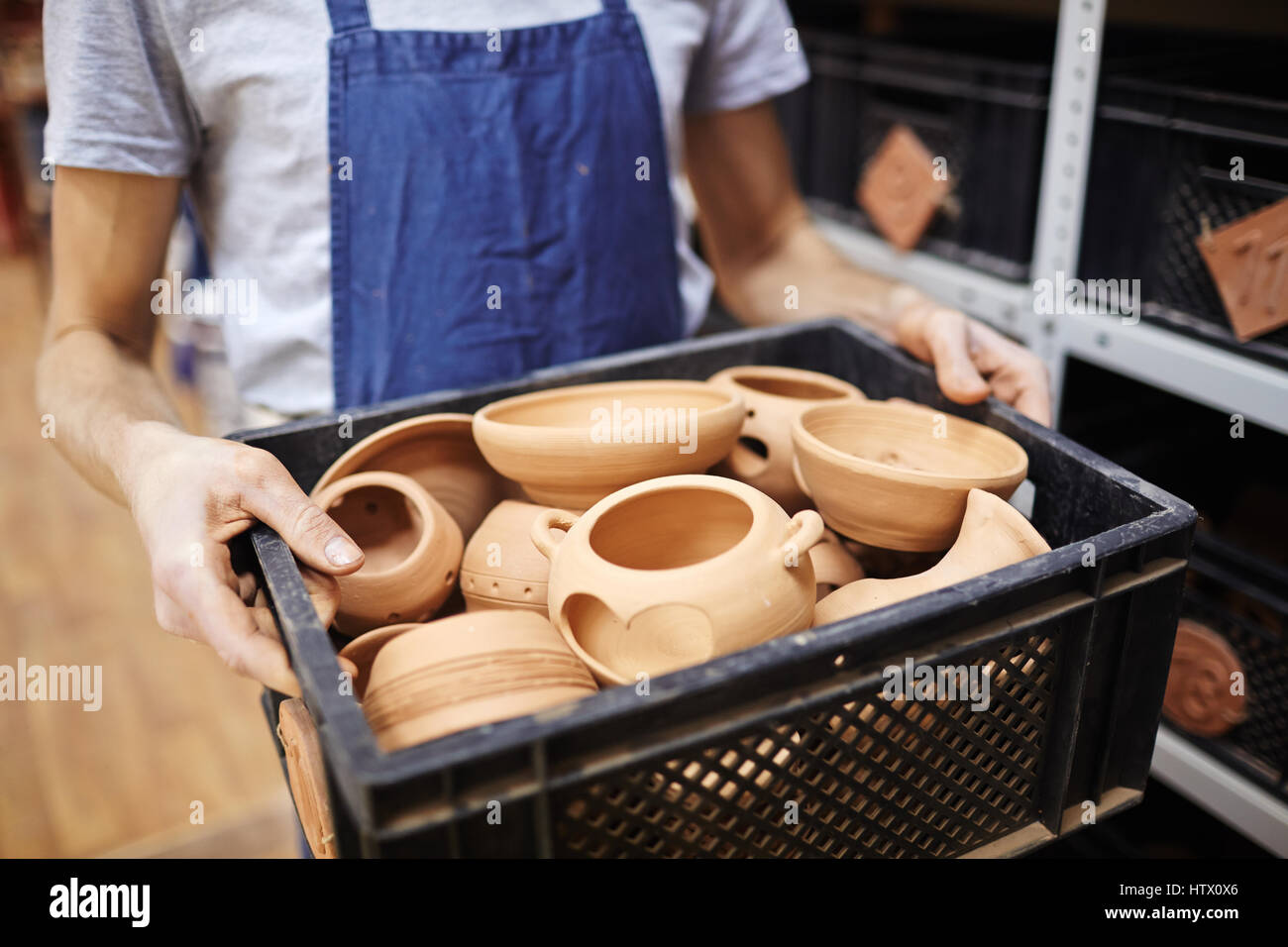 Master of pottery carrying box with clay pots Stock Photo - Alamy