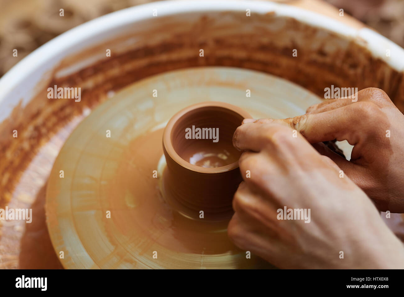 Crockery maker working with rotating fireclay machine Stock Photo - Alamy