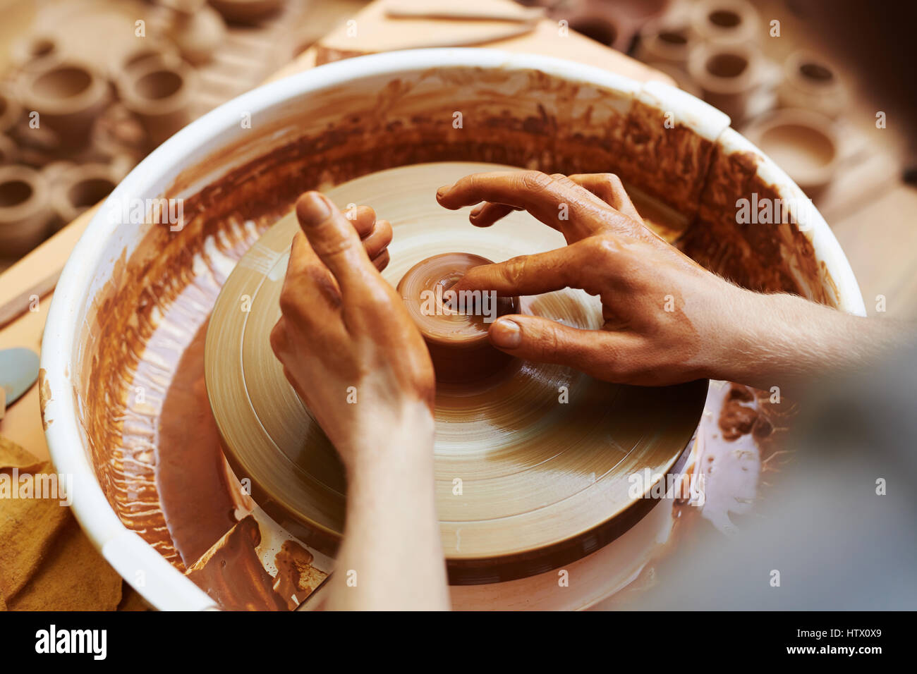 Pottery machine rotating while artisan making jugs Stock Photo - Alamy