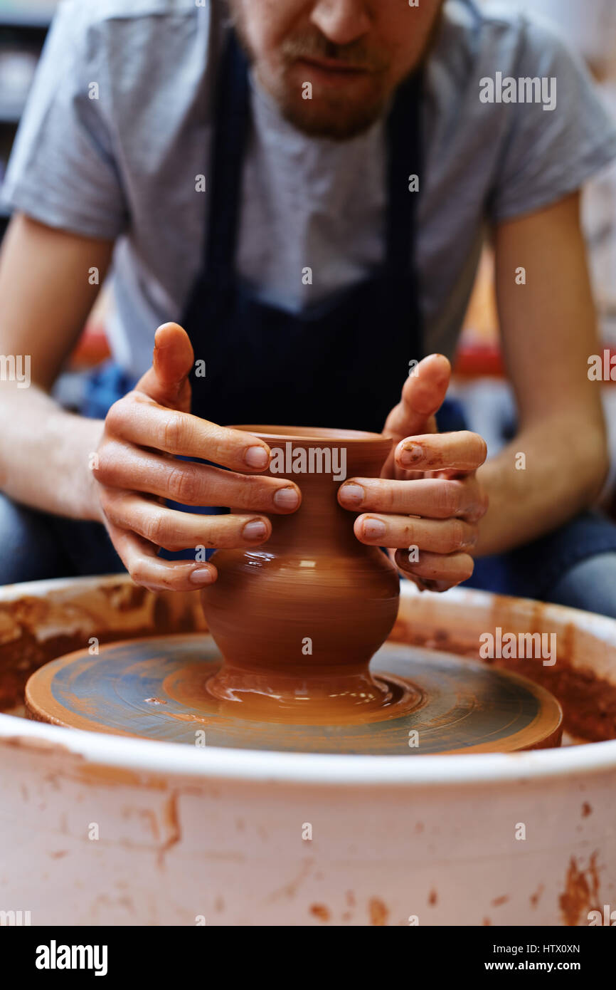 Hands of clay master touching surface of rotating clay jug Stock Photo ...