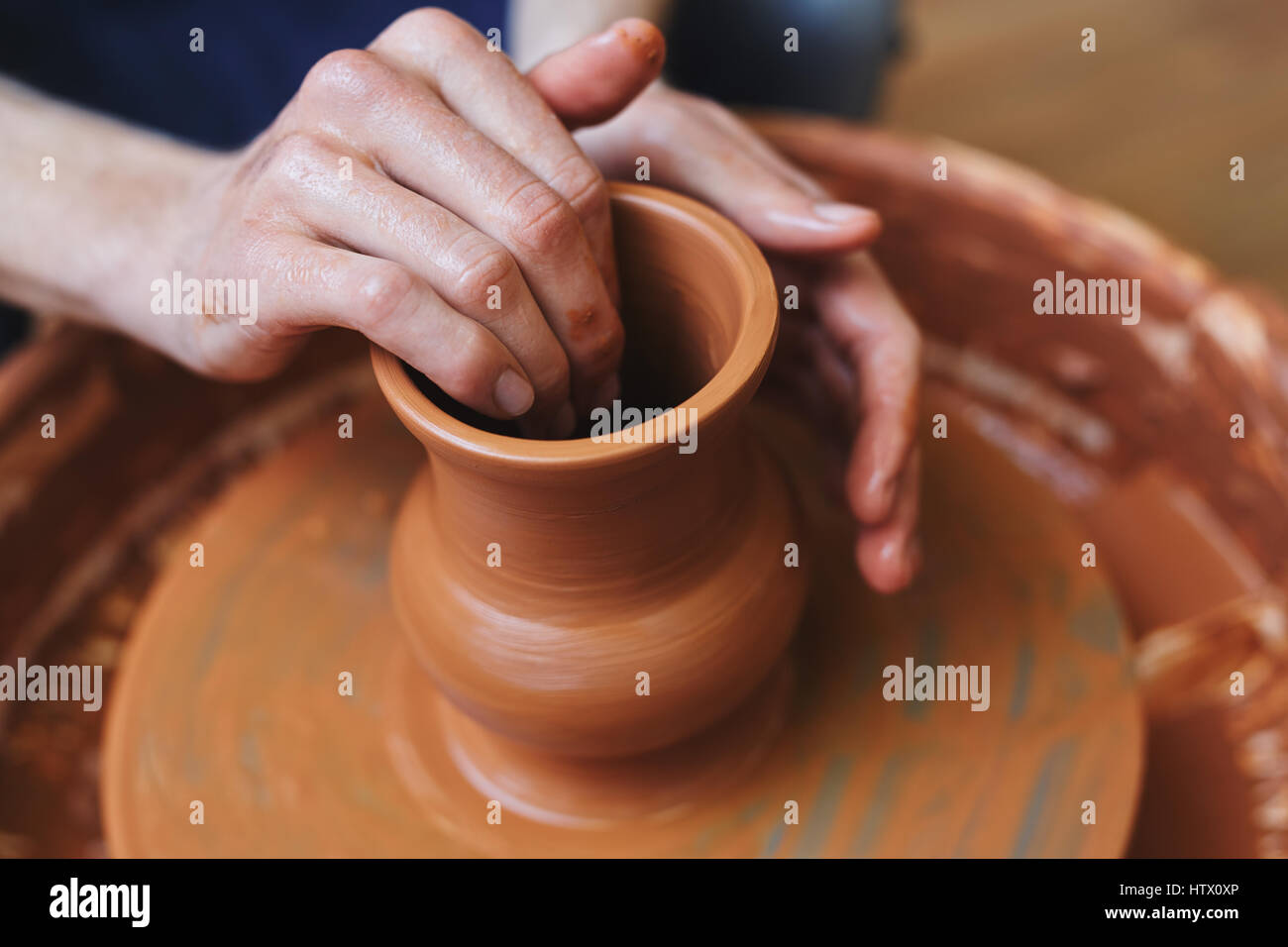 Handicraftsman making fireclay jug in pottery-wheel Stock Photo - Alamy
