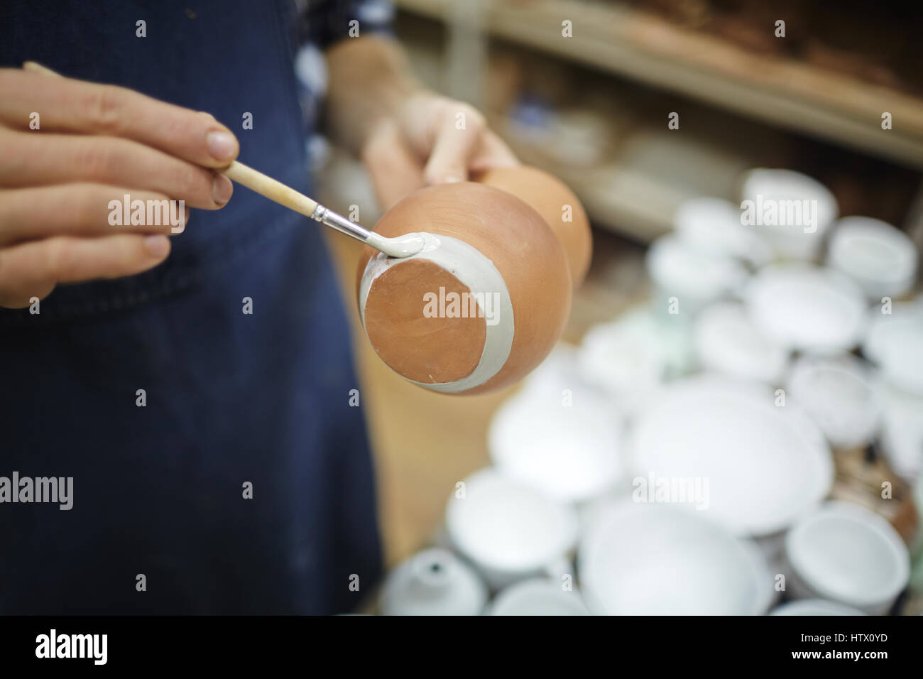 Master of pottery painting jug in white color Stock Photo - Alamy