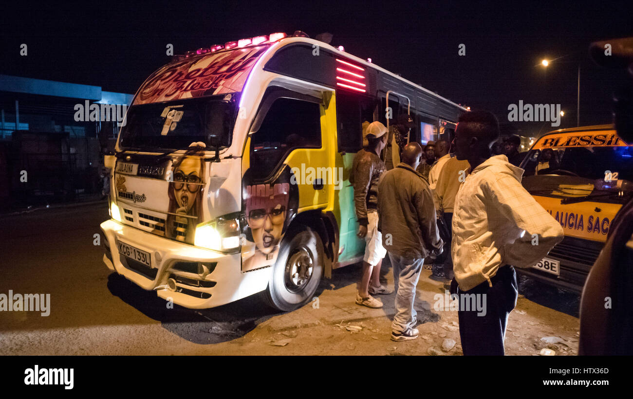 a matatu (bus) vibrantly decorated with lights and paintings stops to ...