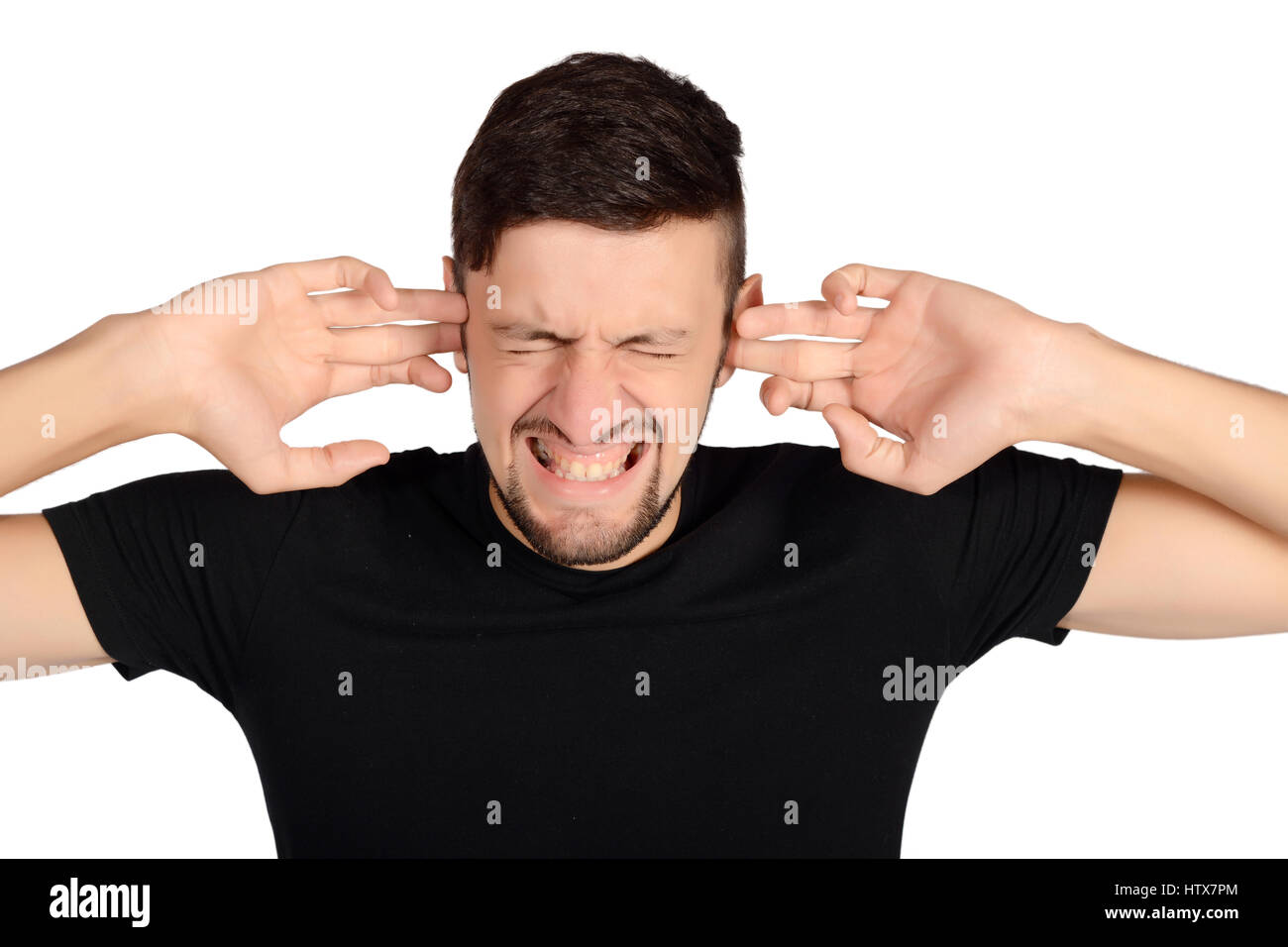 Portrait of a young man covering his ears. Isolated white background ...