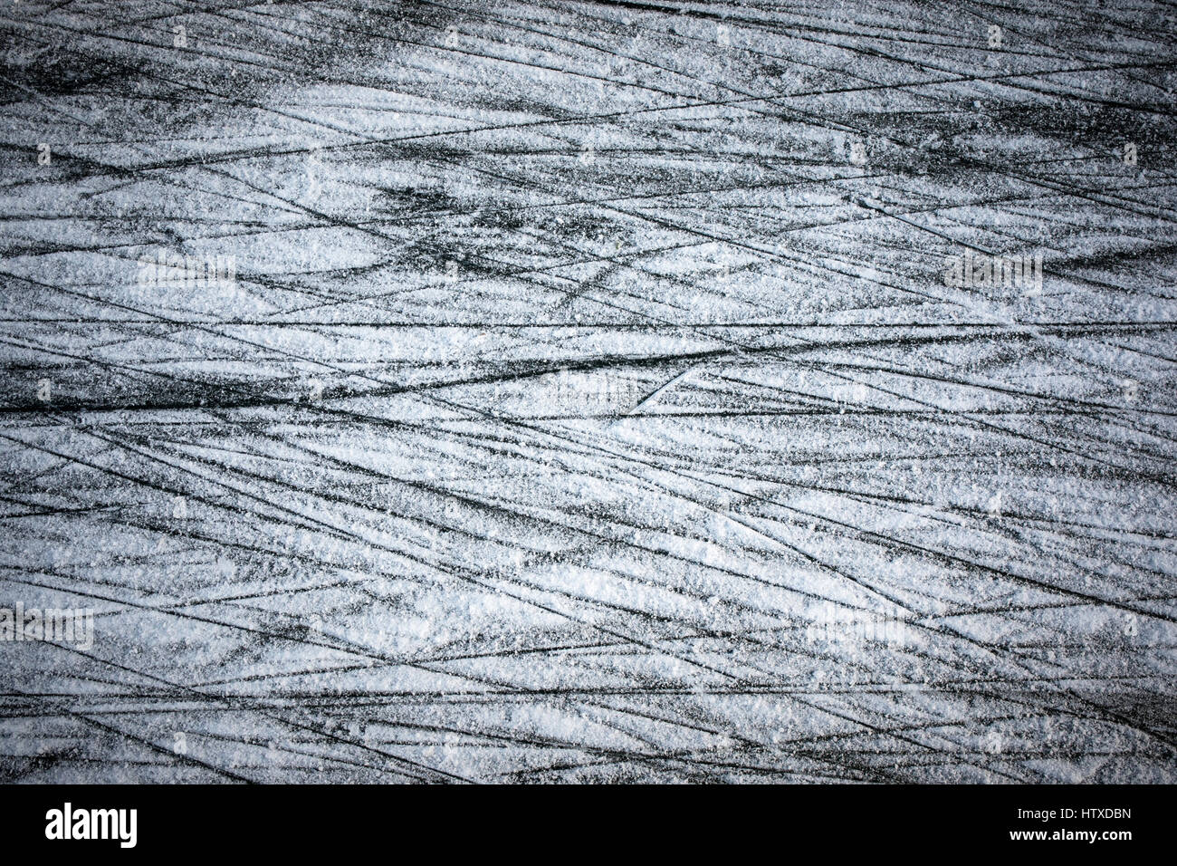 Surface of outdoor ice with snow, replete with skate marks. Abstract ...