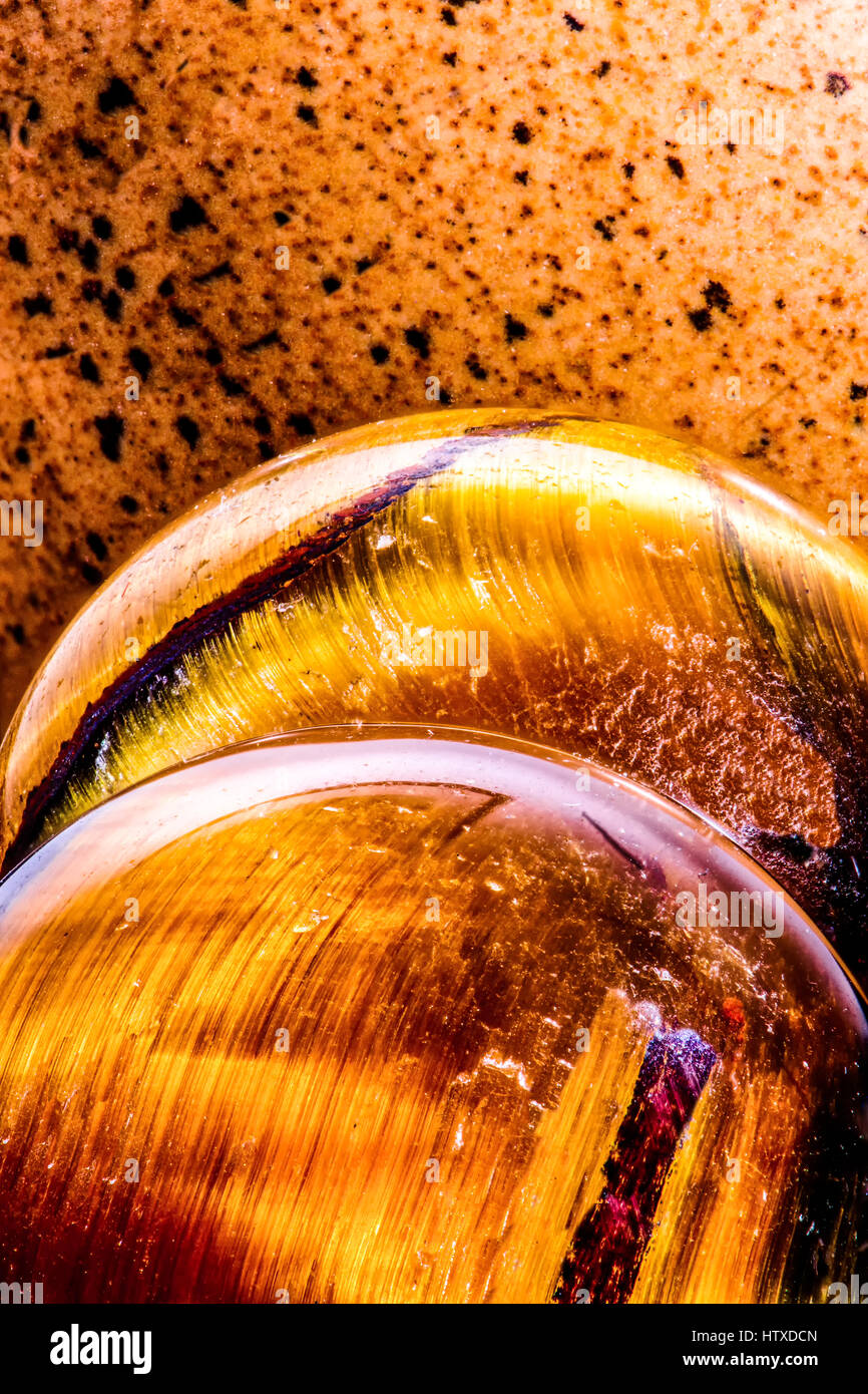 Abstract close-up of two shining stone balls in orange violet golden ...