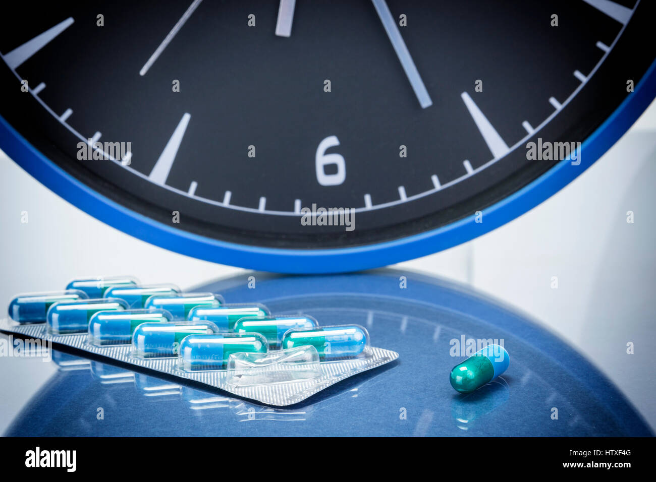 some pills and clock, daily medication treatment Stock Photo - Alamy