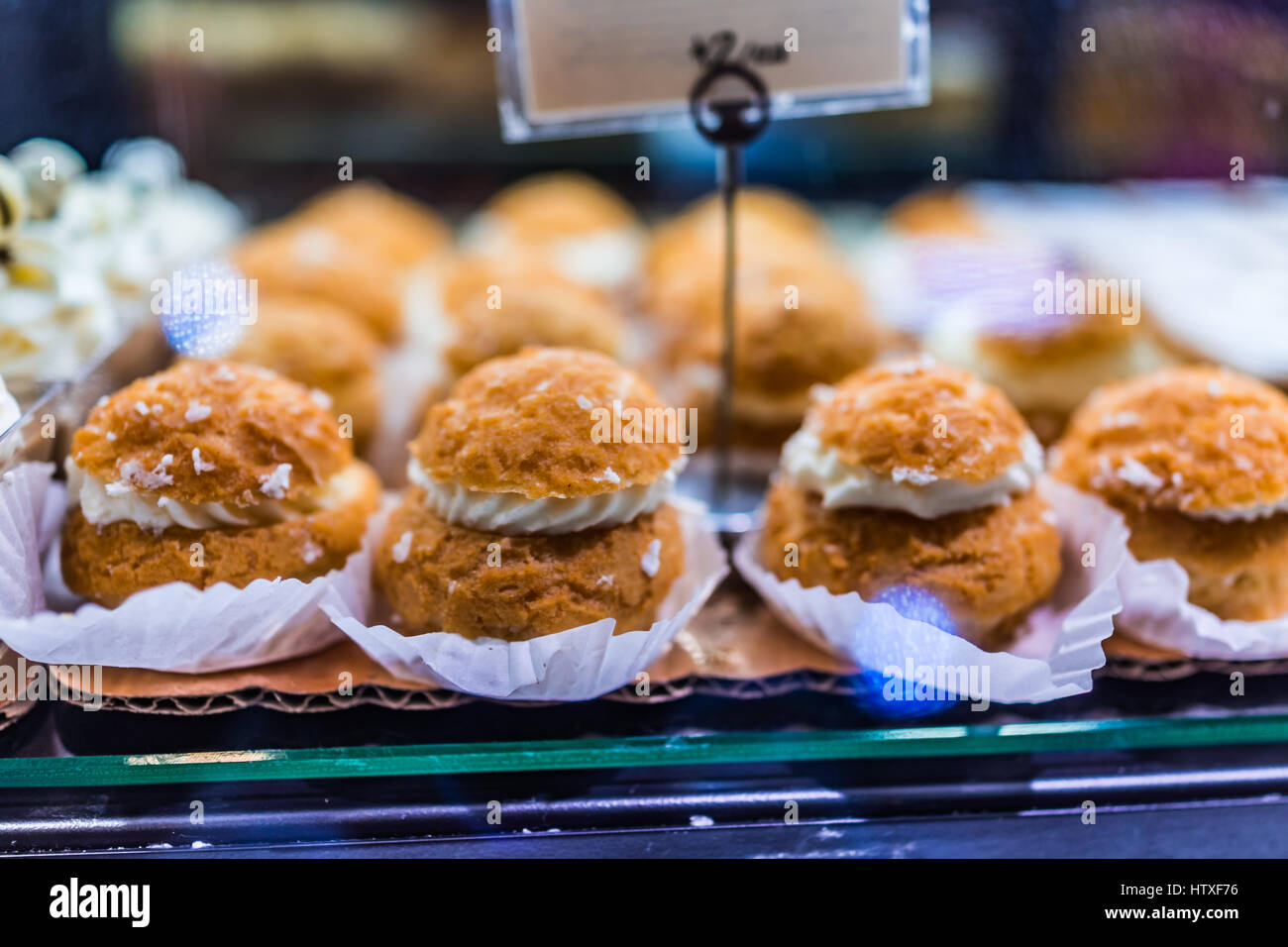 Whipped cream puffs on display in bakery Stock Photo - Alamy