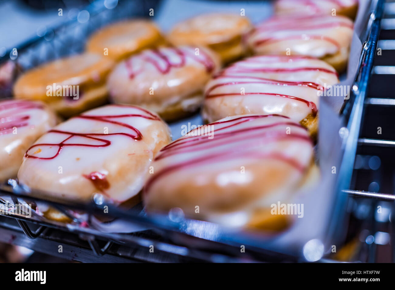 Raspberry white sugar glazed iced donuts with drizzled berry syrup ...