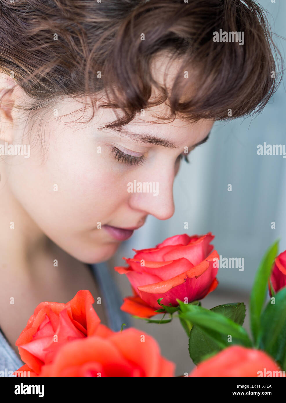 Woman smelling red rose bouquet in vase inside profile Stock Photo - Alamy
