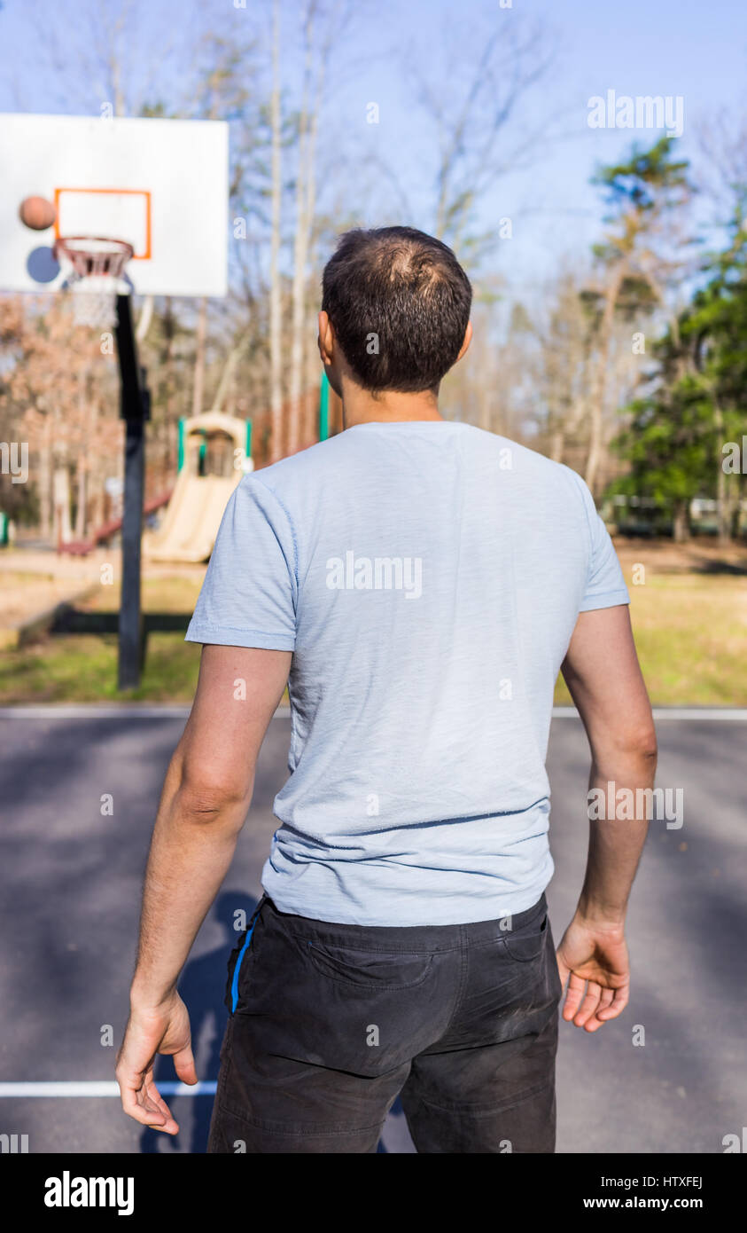 Back of young fit muscular man throwing basketball into hoop Stock ...