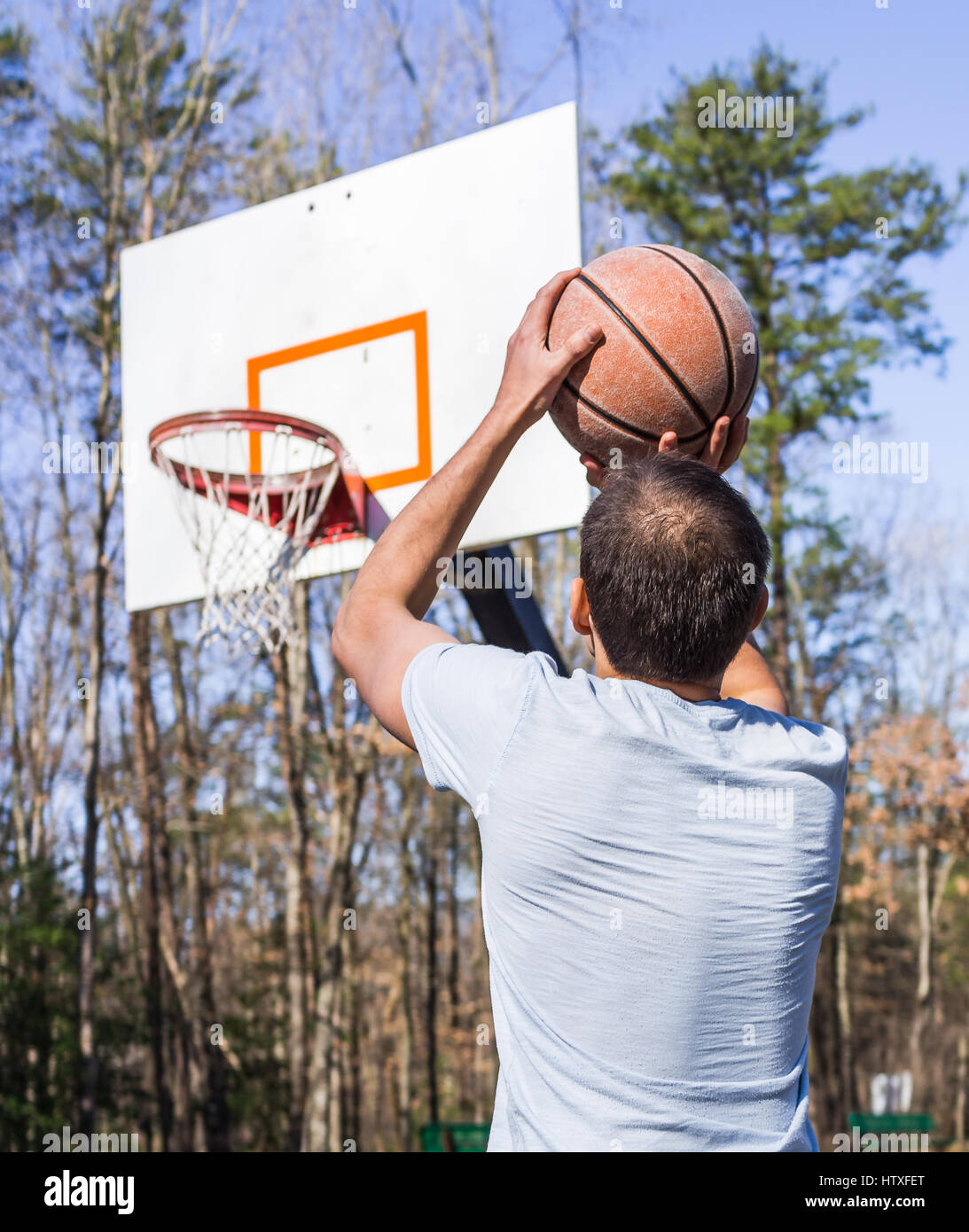 Young fit muscular man jumping up throwing basketball into hoop Stock ...