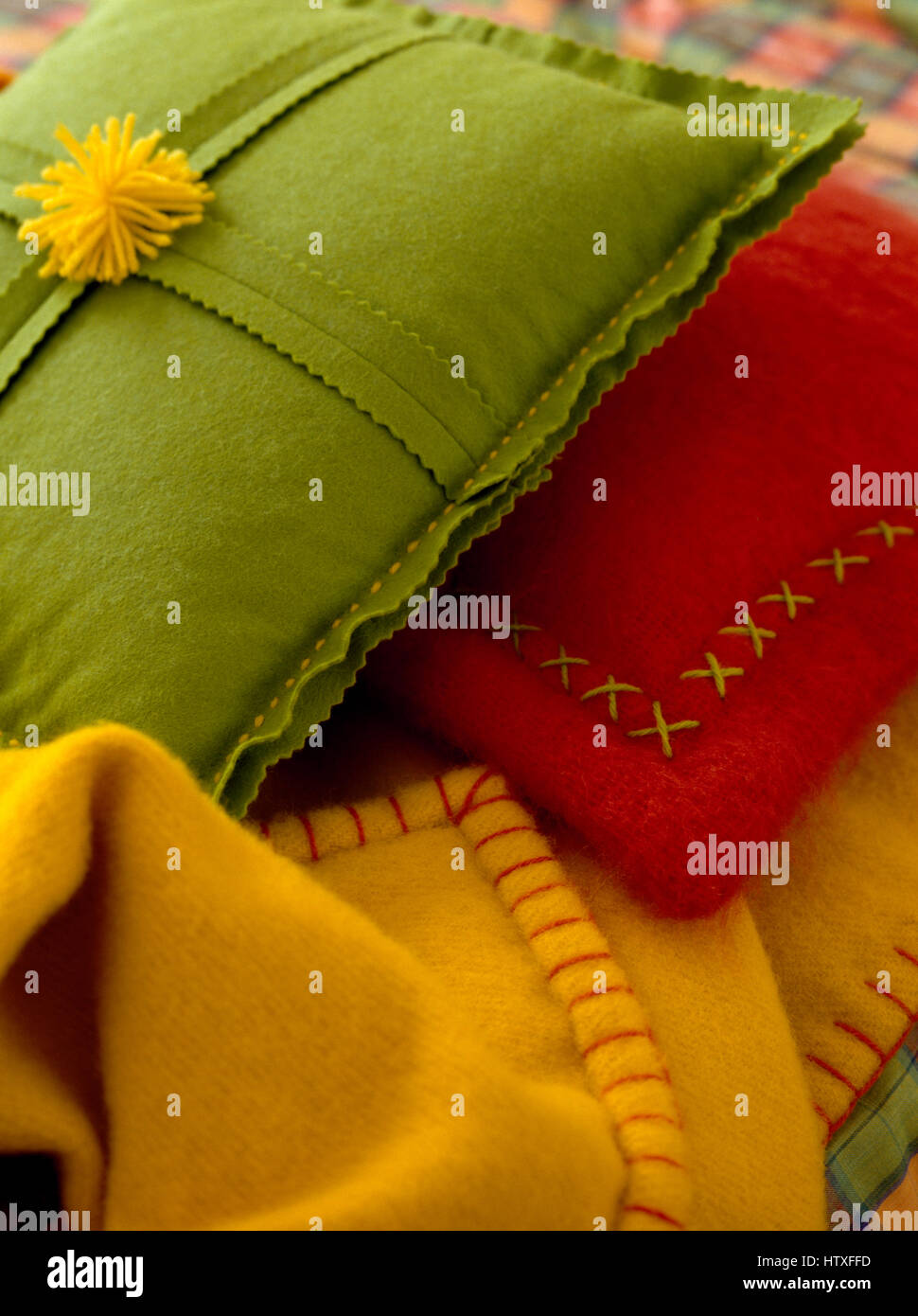 Close-up of colourful felt cushions with decorative cross stitch and ...