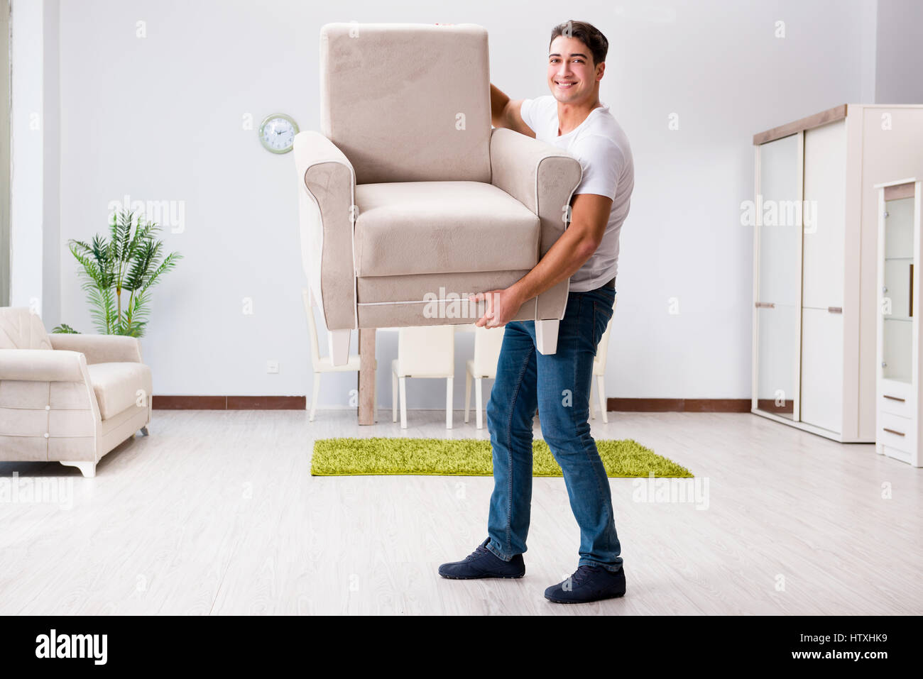 Young man moving furniture at home Stock Photo - Alamy