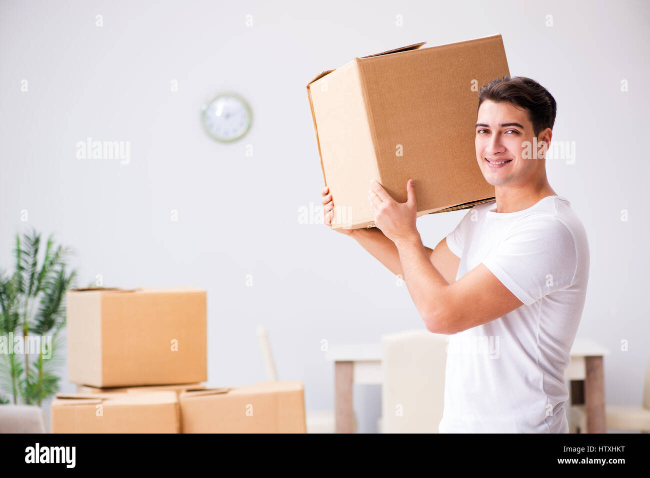 Young man moving boxes at home Stock Photo - Alamy