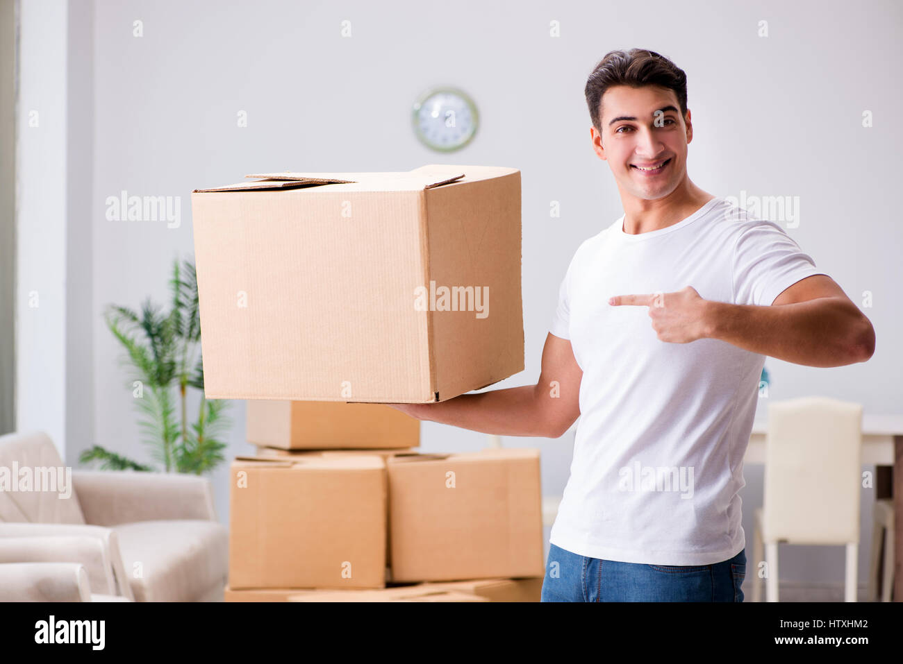 Young man moving boxes at home Stock Photo - Alamy