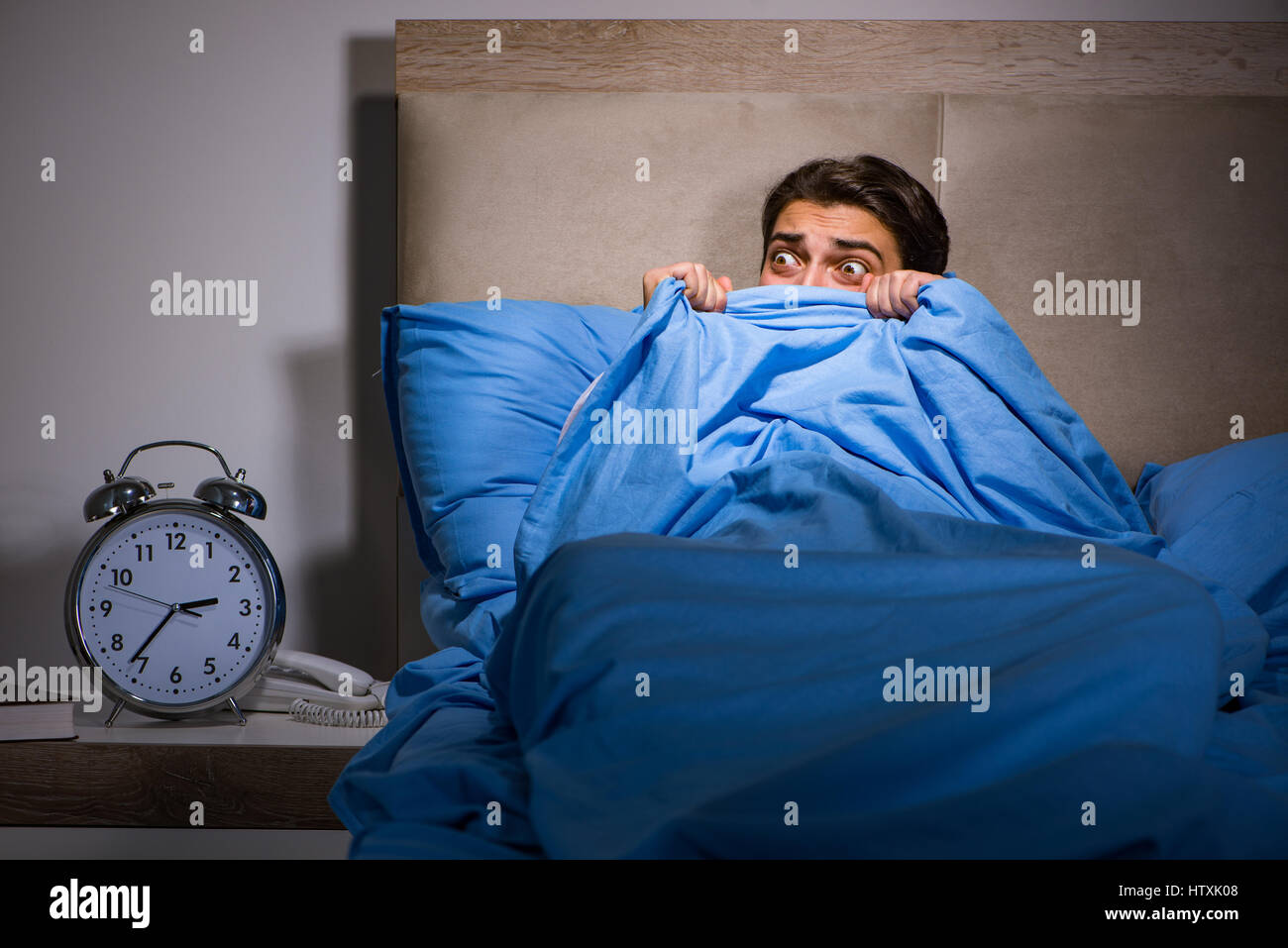 Young man scared in bed Stock Photo - Alamy