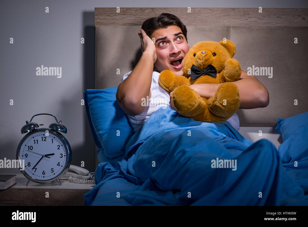 Young man scared in bed Stock Photo - Alamy