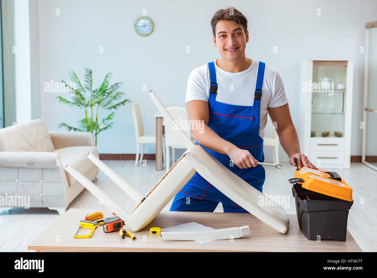 Repairman repairing broken chair at home Stock Photo - Alamy