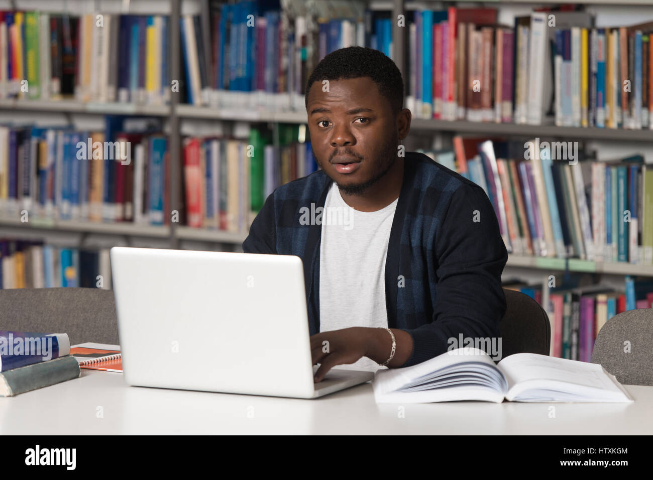 In The Library - Handsome African Male Student With Laptop And Books ...