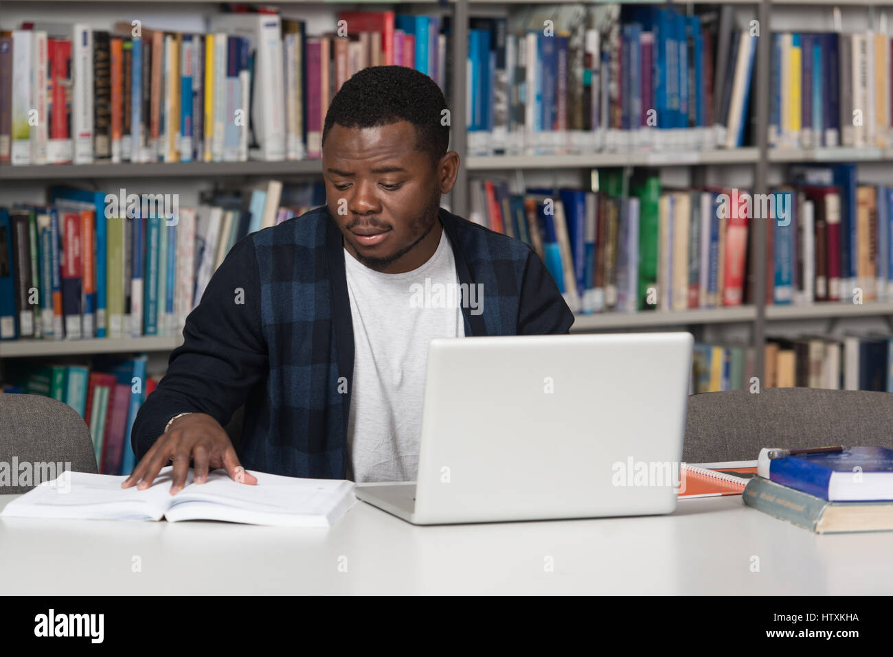 In The Library - Handsome African Male Student With Laptop And Books ...