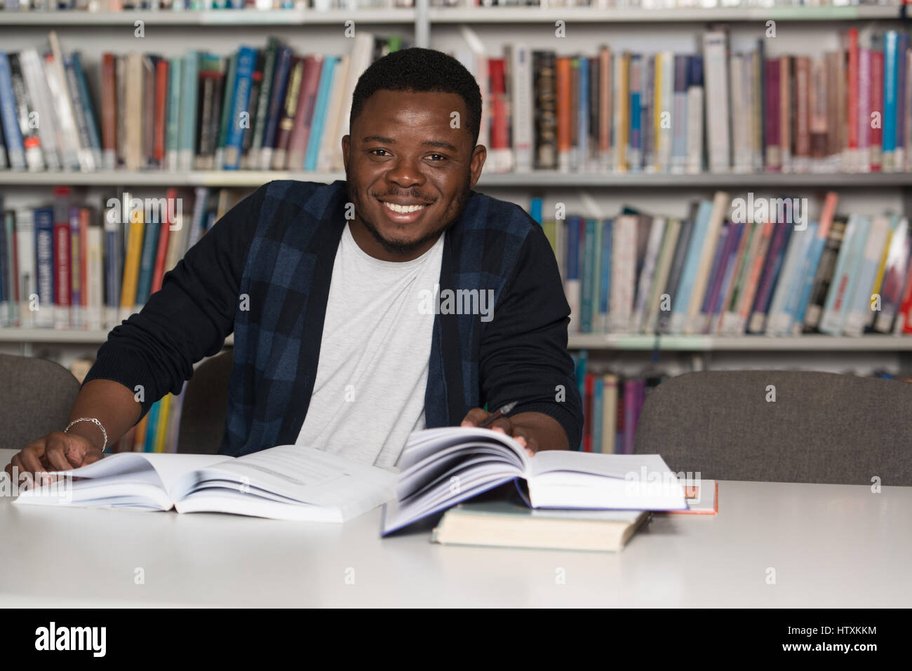 In The Library - Handsome African Male Student With Laptop And Books ...
