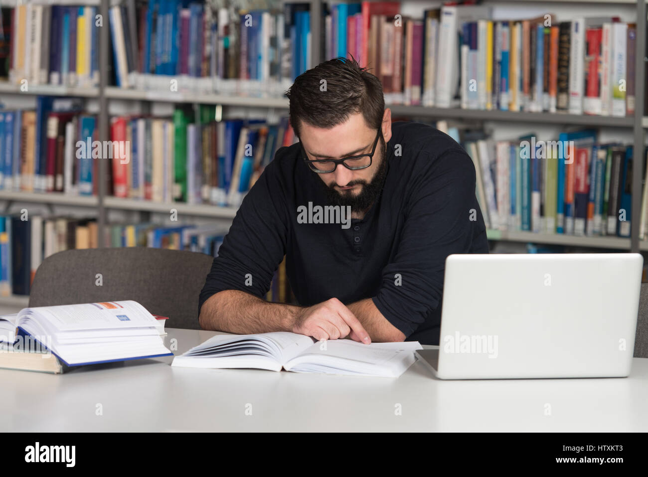 In The Library - Handsome Male Student With Laptop And Books Working In ...