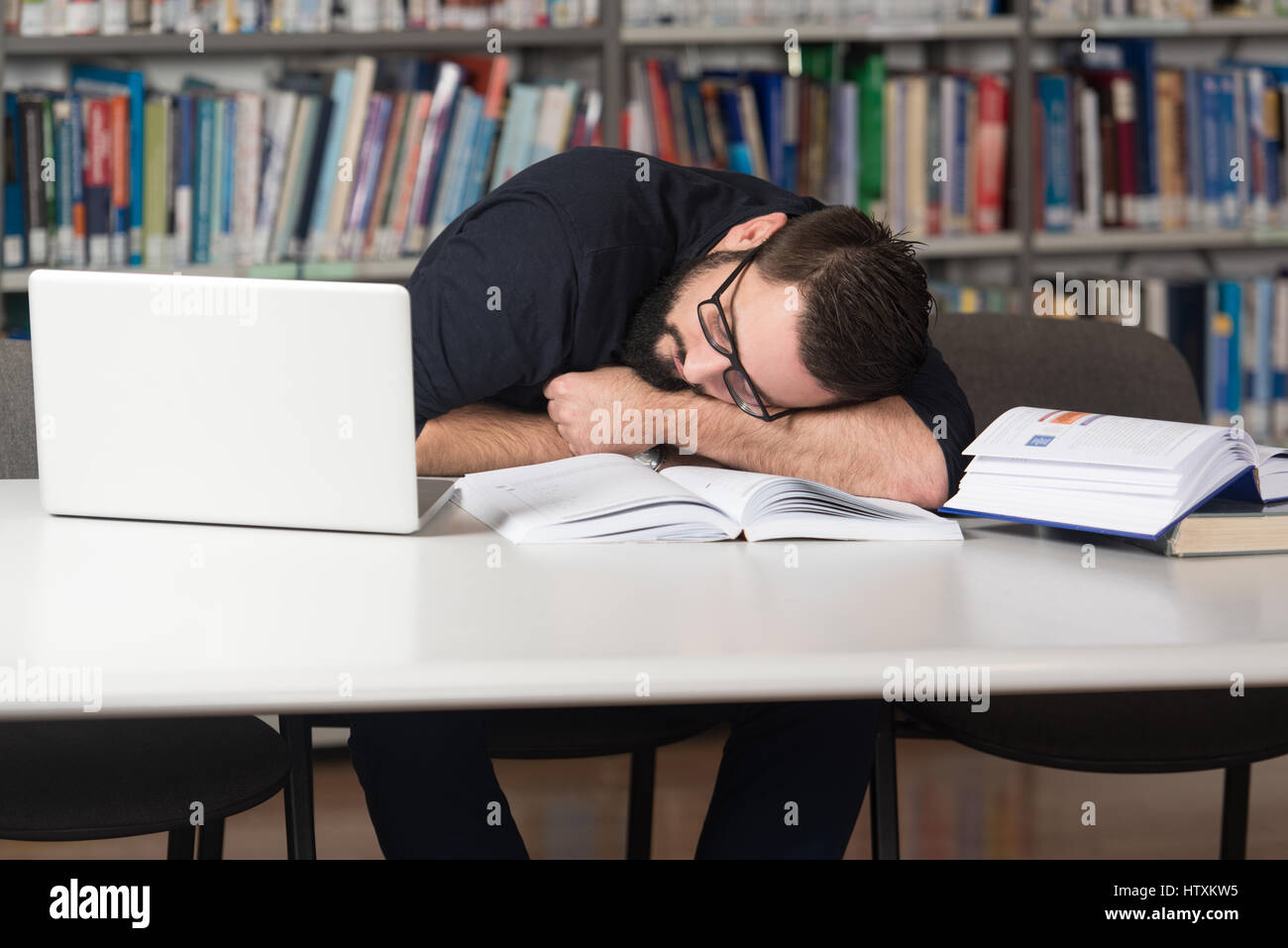 Sleeping Caucasian Student Sitting And Leaning On Pile Of Books In ...
