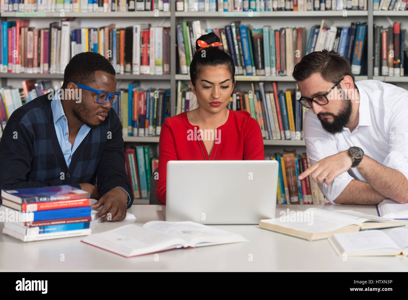 Portrait Of Clever Students With Open Book Reading It In College ...