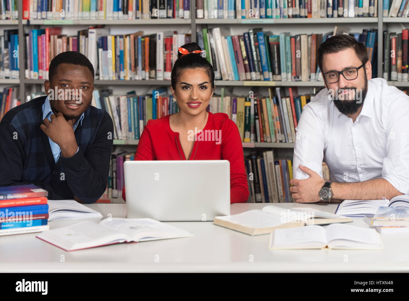 Portrait Of Clever Students With Open Book Reading It In College ...