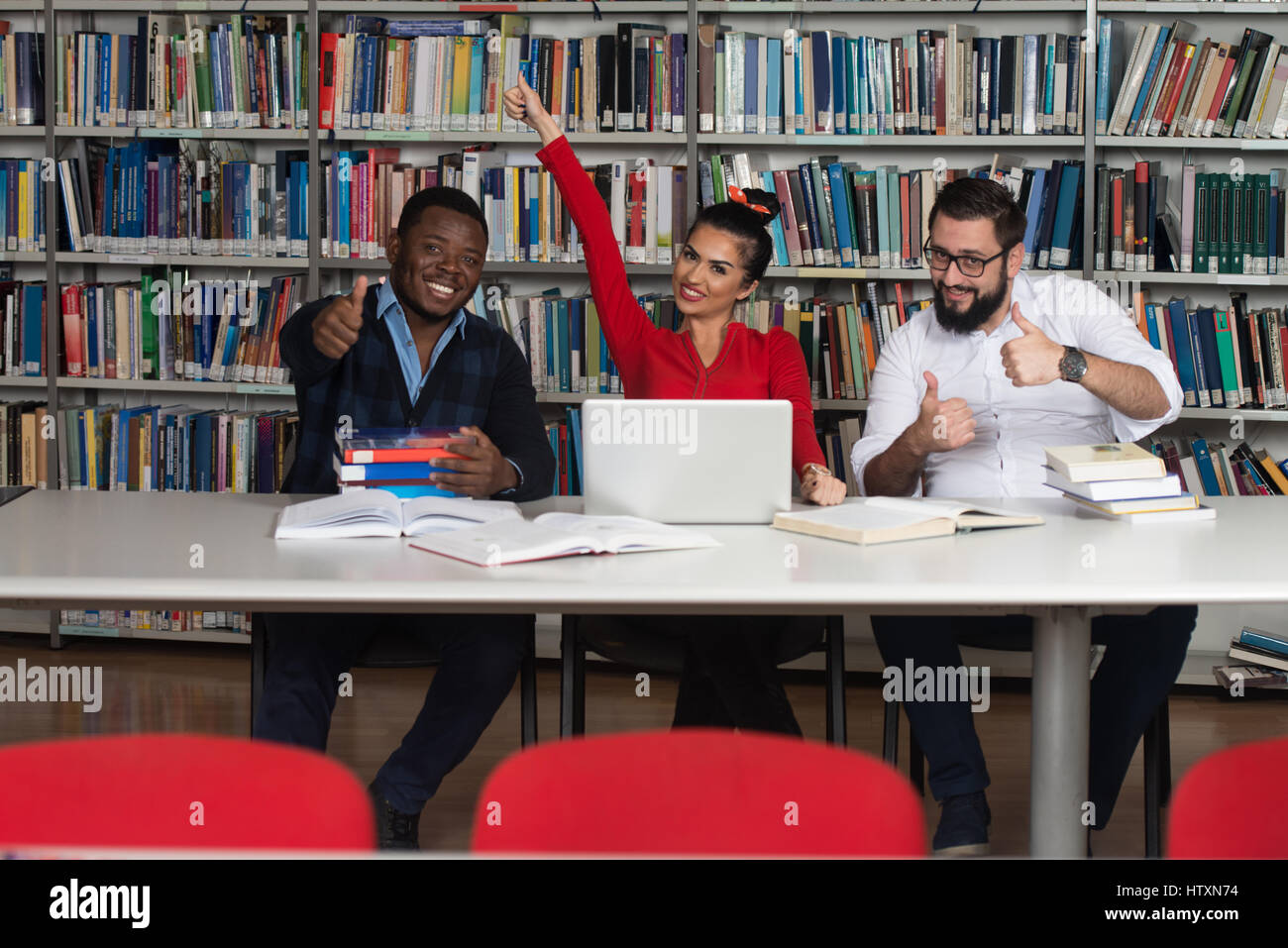 Portrait Of Clever Students With Open Book Reading It In College ...