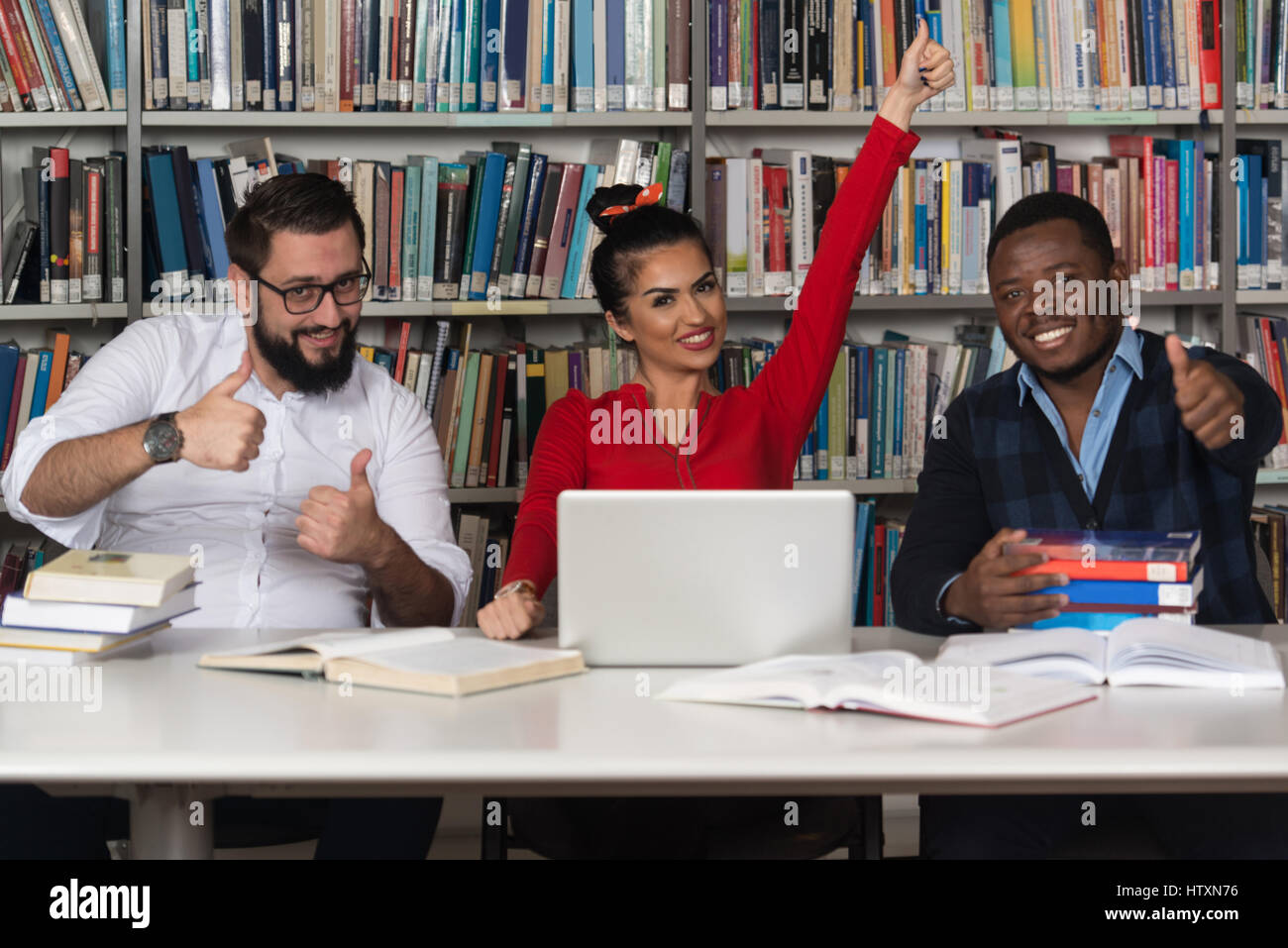 Portrait Of Clever Students With Open Book Reading It In College ...