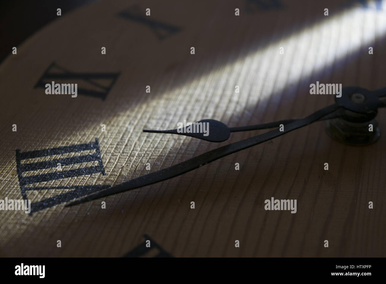 concept of time with a ray of light illumining the hour of an old clock ...